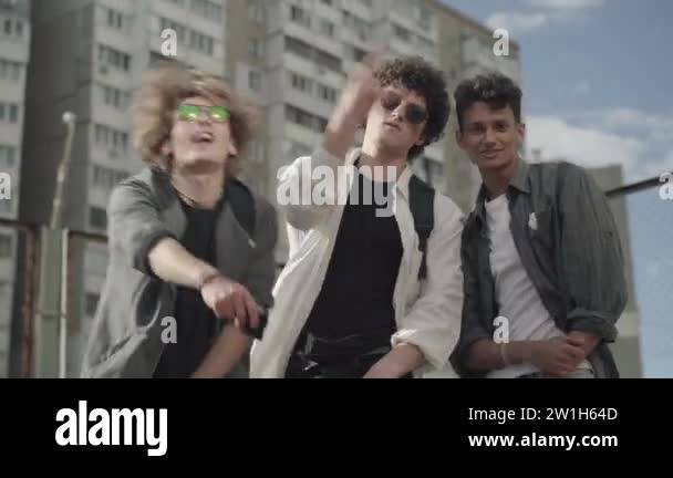 Portrait of three young joyful multiethnic 1980s rappers singing and ...