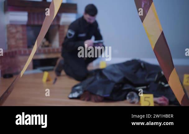 Blurred Caucasian police officer sitting next to the murder victim and ...