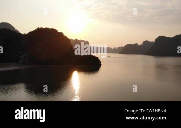 Aerial: flying over Ha Long Bay rock pinnacles at sunset, famous ...