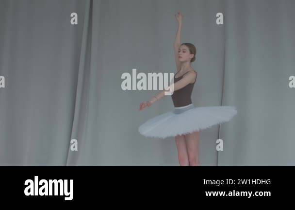 Female dancer ballet on a light coloured background performs smooth ...
