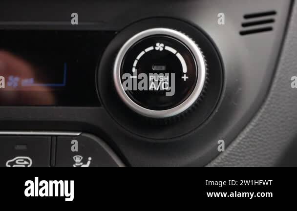 Close-up of pushing a button to turn on the air conditioner in a car ...