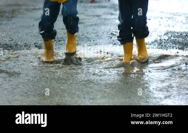 Boys jumping in mud puddle Stock Video Footage - Alamy