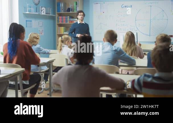 Caring Teacher Explains Lesson to a Classroom Full of Bright Diverse ...