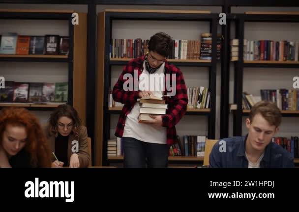 Slow motion footage of a guy in plaid shirt and headphones walking by ...