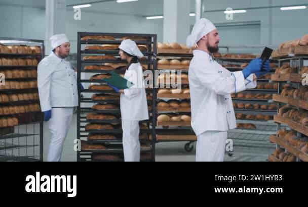 In a bakery industry main baker man take some notes and photo using a ...