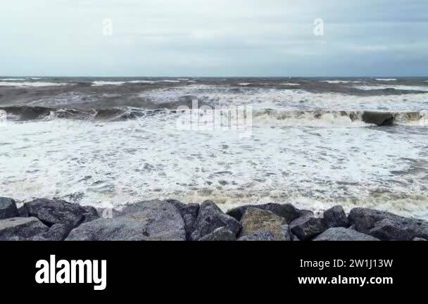 Choppy sea with hard waves hitting rocks at the shoreline during ...