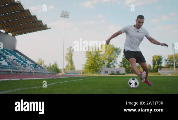A soccer player at the stadium demonstrates dribbling with a soccer ...