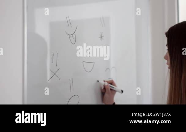 Young skinny good looking girl drawing happy smiley faces marker on ...