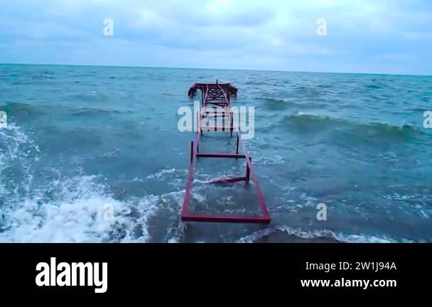 Sea storm, waves crashing against the pier. Splashes on the dock, foam ...