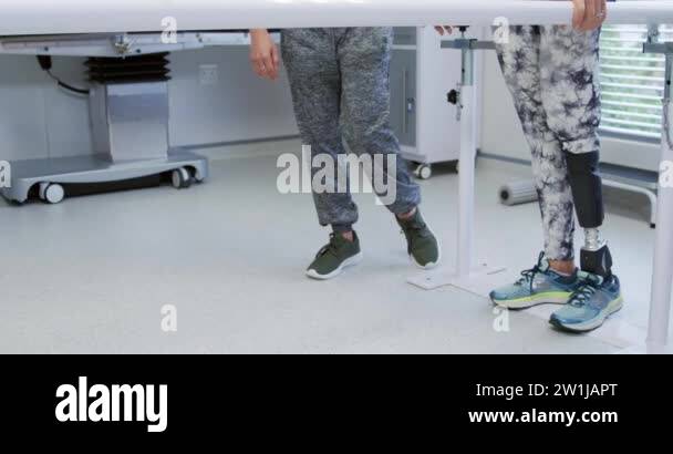 Side view low section of a Caucasian female physiotherapist helping a ...