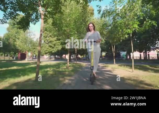 Front view of Joyful adorable senior woman using a scooter while riding ...