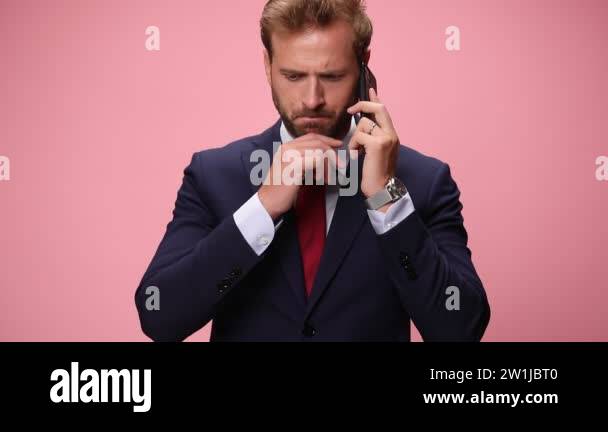 concerned elegant man in navy blue suit talking on the phone, holding ...