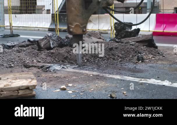 Jackhammer Crumbles Asphalt Pavement. Impact tip splits the thick ...