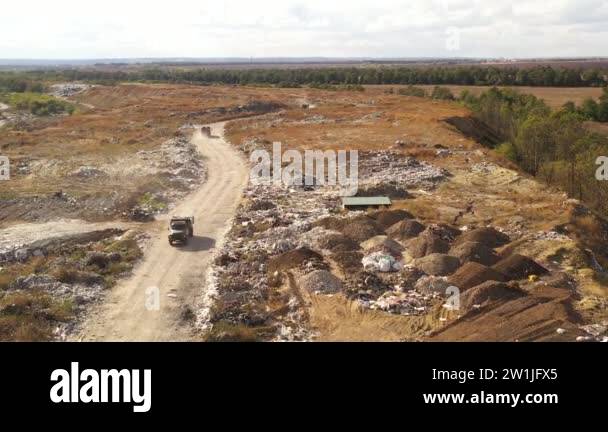 Trucks bring waste to a Garbage pile in trash dump. Aerial view of ...