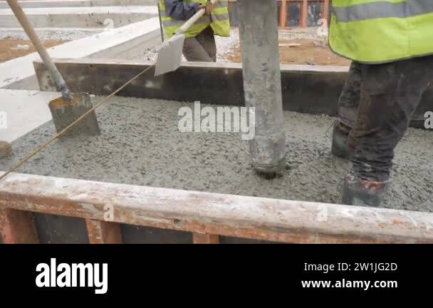 Pouring concrete mix from cement mixer on concreting formwork. Finished ...