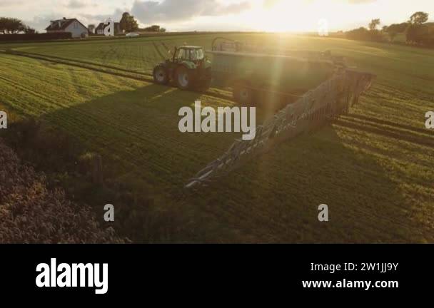 Farming Tractor Going Backwards on a Vast Field of Plantation Crops ...