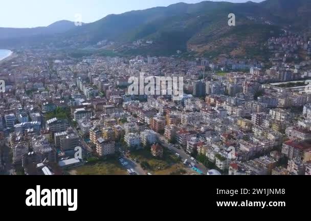 Top view of resort city in front of high green mountan in clouds. Art ...