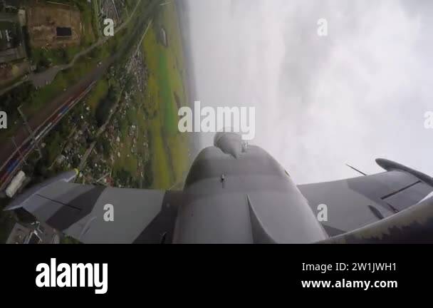 Gray blue combat fighter plane make barrel roll maneuver against a ...