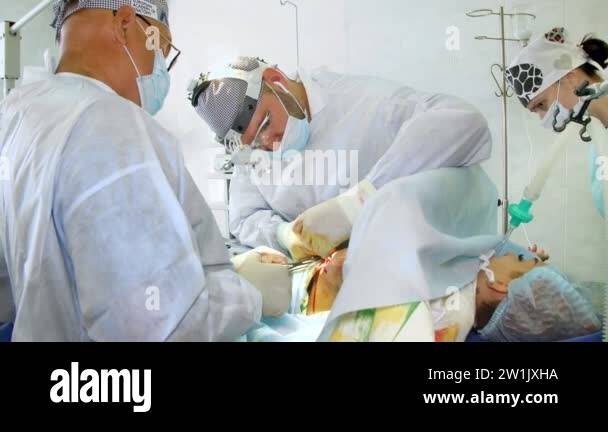 The surgeon and his assistant suture the incisions under the mammary ...