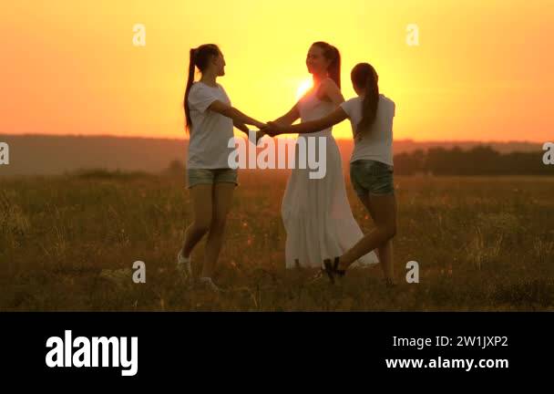 young mother with healthy daughters and sisters dance together in a ...