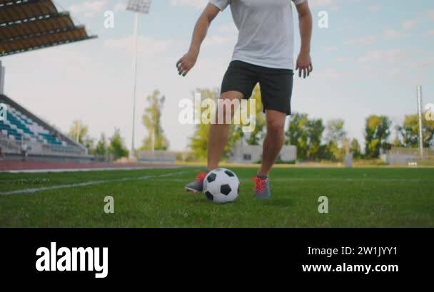 A soccer player at the stadium demonstrates dribbling with a soccer ...