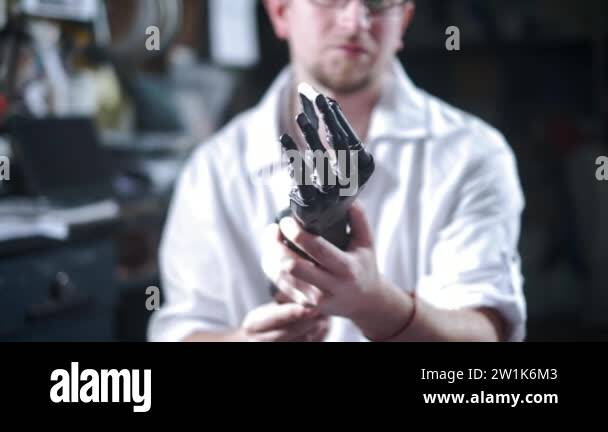 A scientist engineer is testing an electronic bionic prosthetic arm. He ...