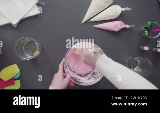 Step by step. Flat lay. Mixing in food coloring into the royal icing to ...