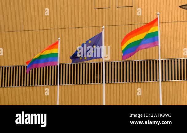 The Pride flags and European Union flag on white flagpoles against the ...
