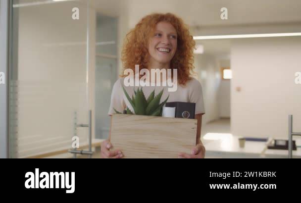 Happy young woman getting promotion and leaving office with things in ...