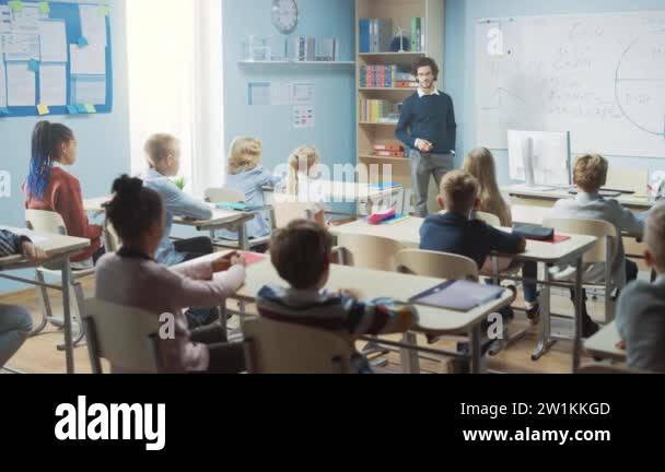 Caring Teacher Explains Lesson to a Classroom Full of Bright Diverse ...