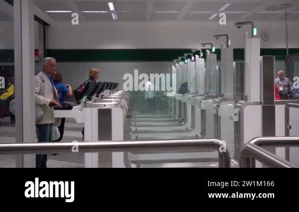 Air travelers pass through automated passport border control gates ...
