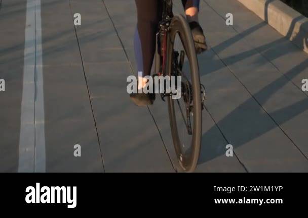 Woman cyclist is cycling on bike. Bike wheels rotation, close up ...