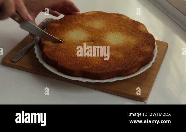 Vegetarianism, pie making. The cook cuts off a piece of baked pie with ...