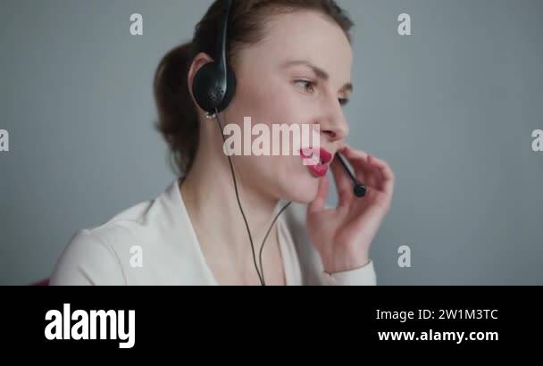 Call-centre lady employee happy of conversation with customer calling by headset answering ...