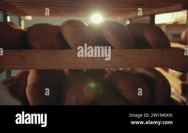 Pushing, moving forward shelving with loaves of brown bread, flare of ...