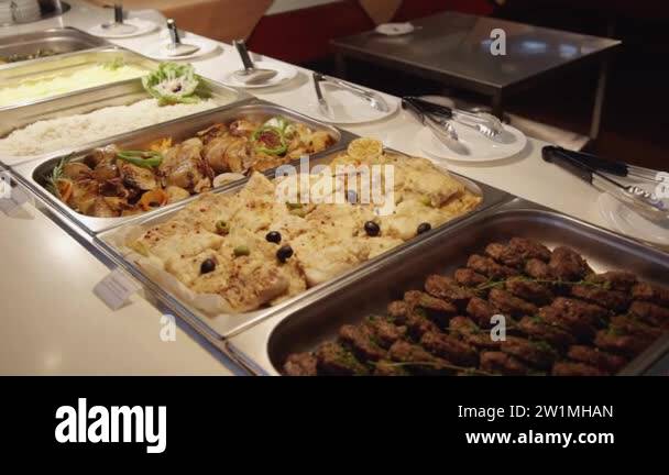Varied cooked food in containers for buffet in interior of modern ...