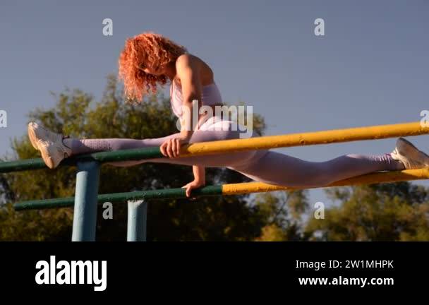 a young athlete stretches the muscles of the legs, doing splits on the ...