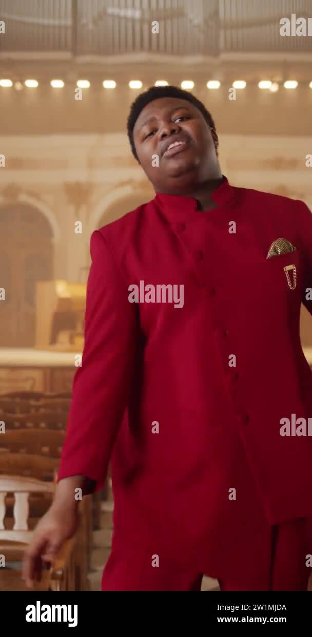 Joyful african american gospel singer standing at row of wooden pews ...