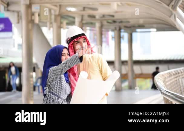 Arab engineer consult construction project together hold blueprint ...