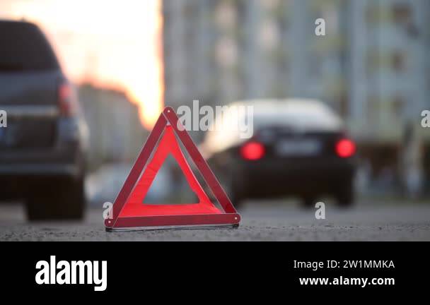 Red emergency stop sign behind broken blurred car with blinking lights ...