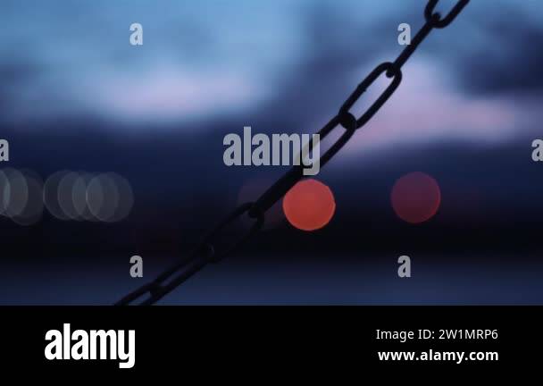 metal chain, with a moving, blurry, blue, plain background and blinking ...