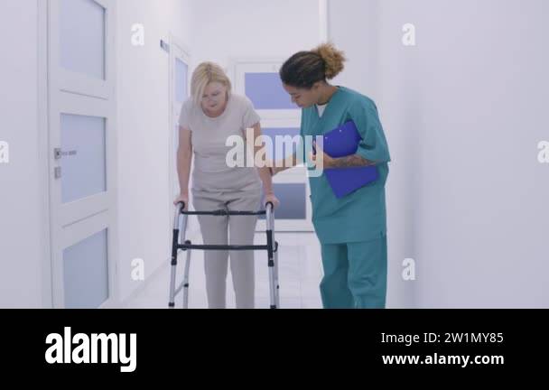 Rehabilitation after disease doctor helping weak female patient walk ...
