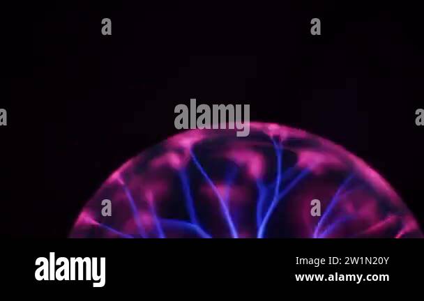 Plasma lightning ball moves randomly and stops in the centre on a black ...