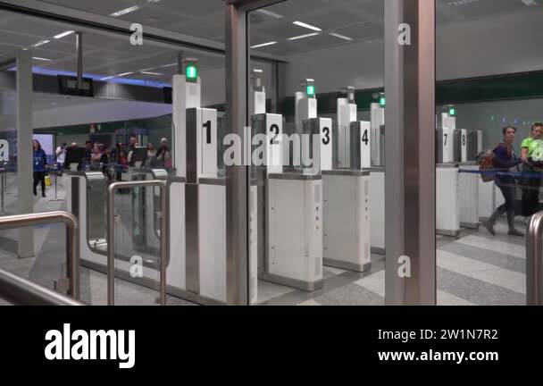 Air travelers pass through automated passport border control gates ...
