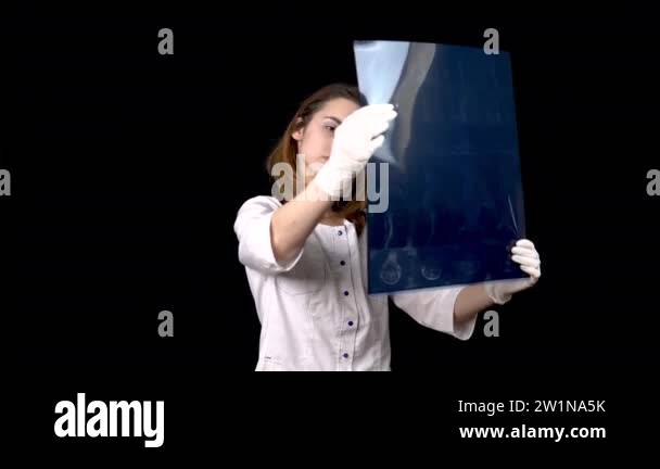 A young woman doctor checks the results of an MRI scan of a spine. A ...