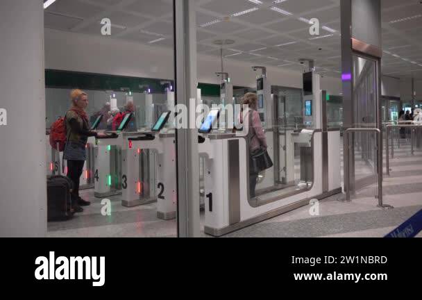 Air travelers pass through automated passport border control gates ...