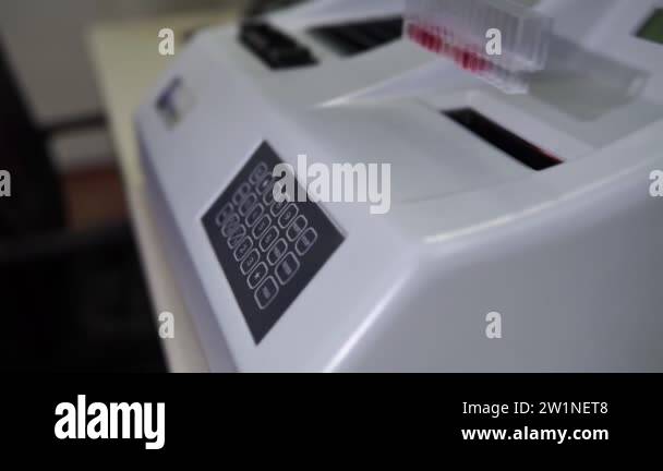 Female lab technician sets up a laboratory machine for blood analysis ...