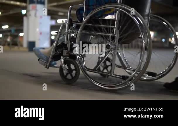 Wheelchair rides bottom view. A woman carries a disabled person in a ...