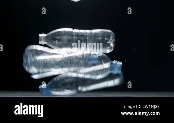 Plastic pollution. Plastic Bottle falling down on black background ...