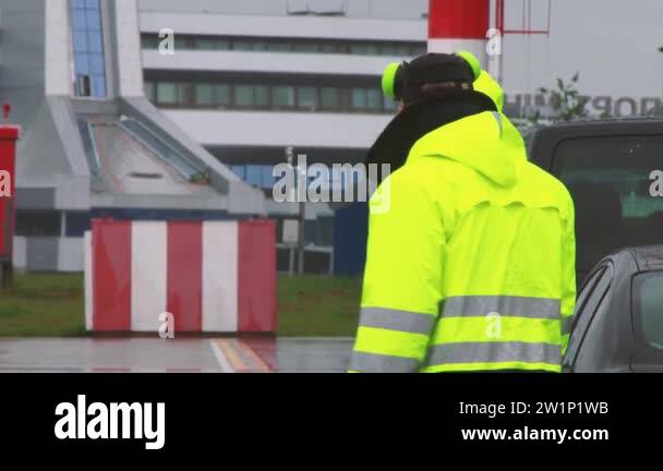 Airport supervisor wearing a protective medical mask stands on the runway. Aviation staff back ...